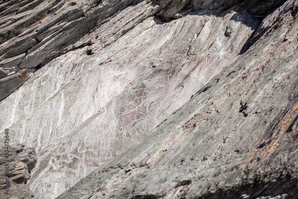 Old rock carvings of an ancient man on rocks in Siberia. The drawings ...