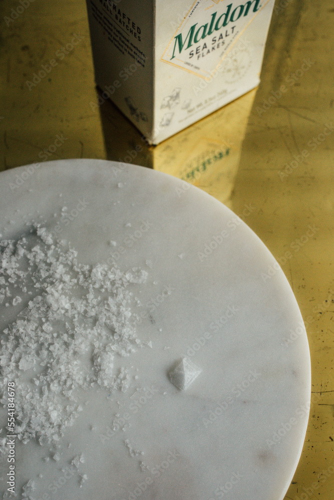 Maldon salt flakes with single pyramid shape salt crystal on white ...