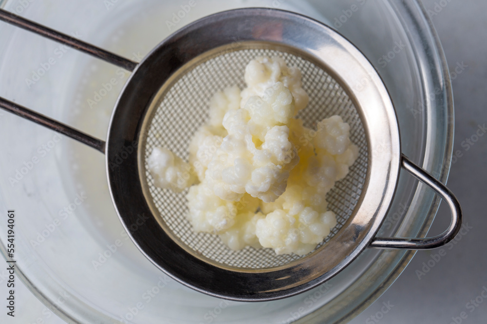 Kefir fermented milk drink with kefir grains. Homemade kefir stands in ...