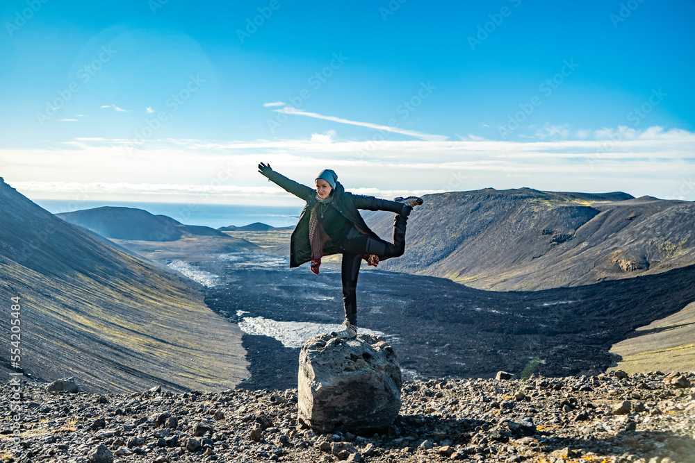 young woman poses for camera on the rock at Fagradalsfjall volcano ...