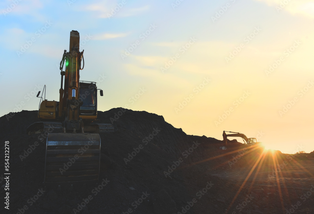 Excavator working on earthmoving at open pit mining on amazing sunset ...