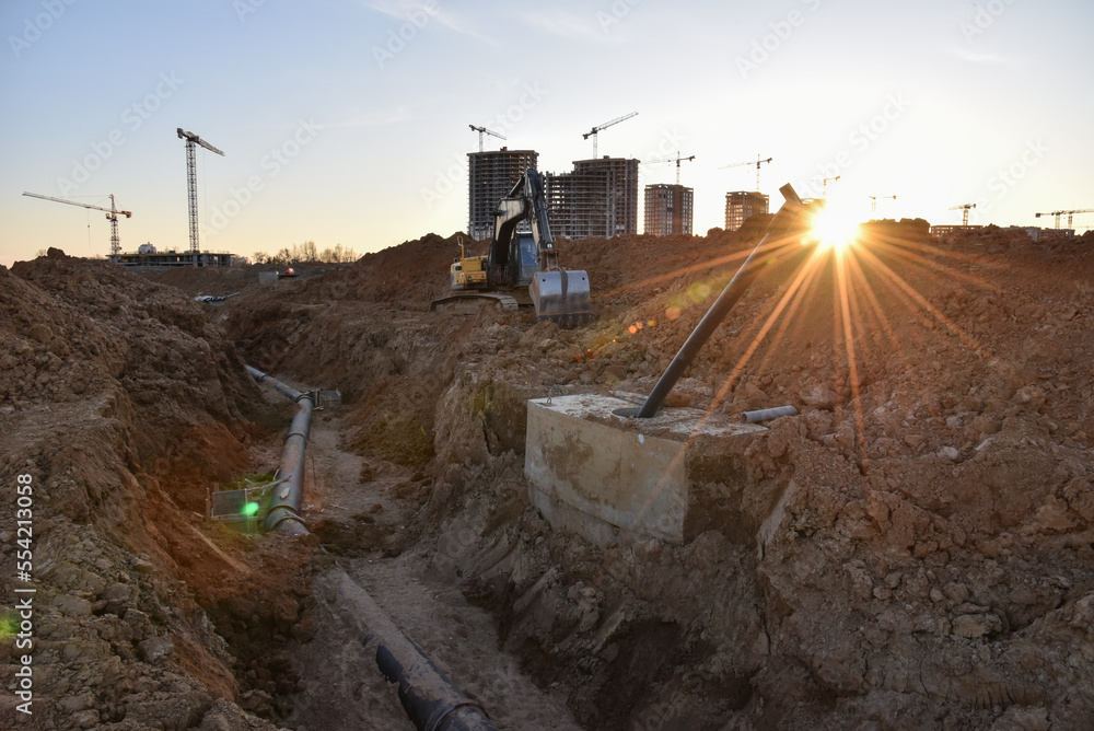 Sewer pipes laying. Sanitary drainage, external sewage. Tower crane on ...