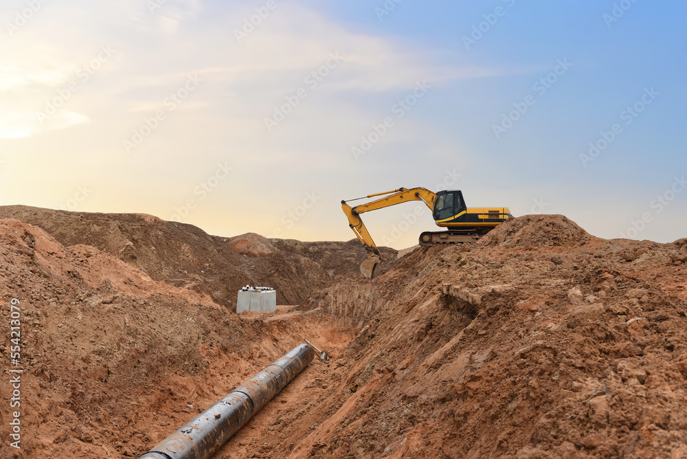 Sewage drainage system mounting at construction site. Excavator during ...