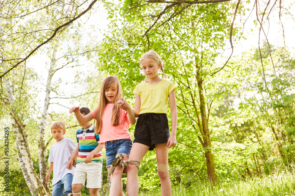 Children playing three legged race competition in park Stock Photo ...