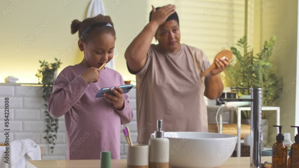 Curvy Black woman and her little daughter getting ready together in ...