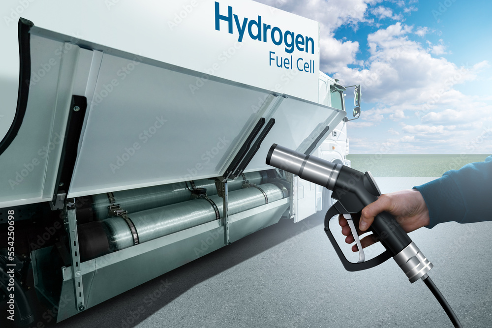 Hand with H2 nozzle on a background of hydrogen fuel cell semi truck ...