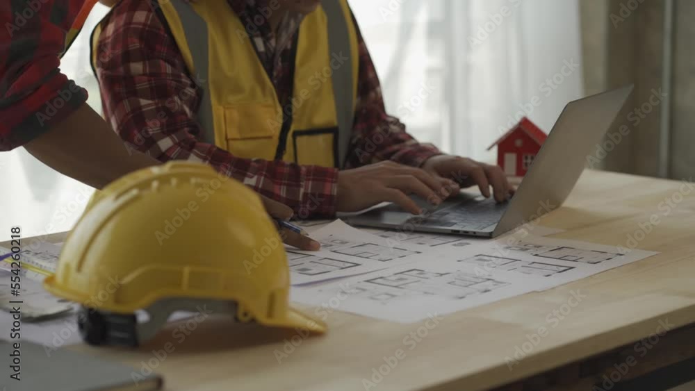 Engineer looking at blueprints and planning building construction on ...