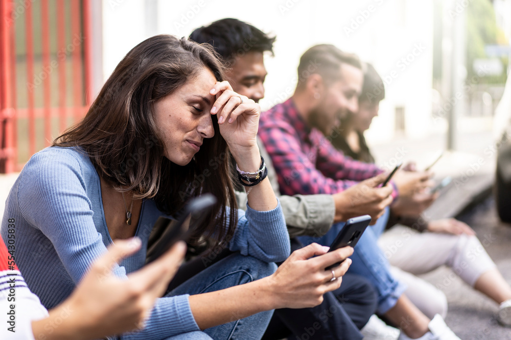 Pensive friends group using smartphone sitting at university college ...