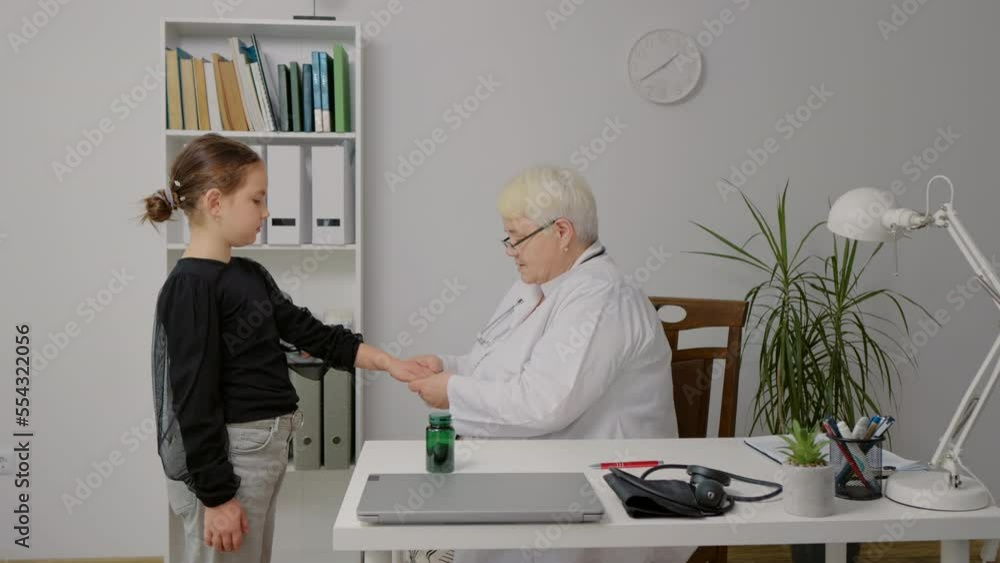 Female doctor examining child hands asking where it hurts. Happy child ...