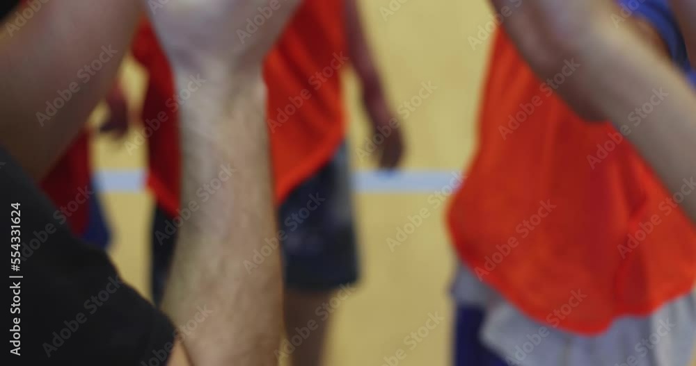 Team of kids children basketball players stacking hands in the court ...