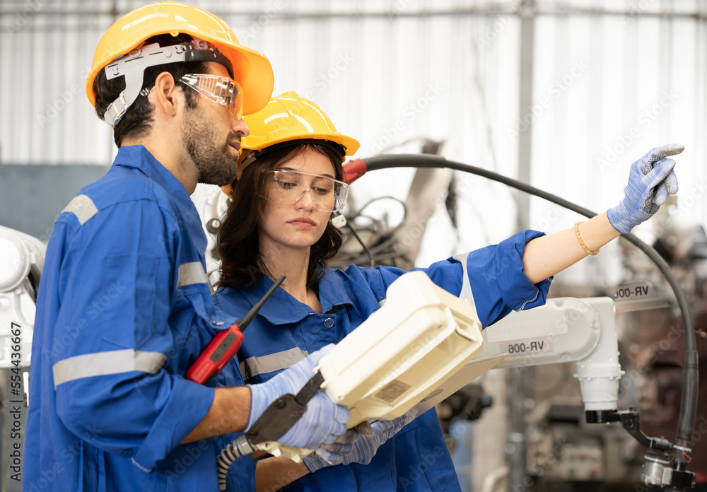 Male industrial engineer using remote control board to check robotic ...