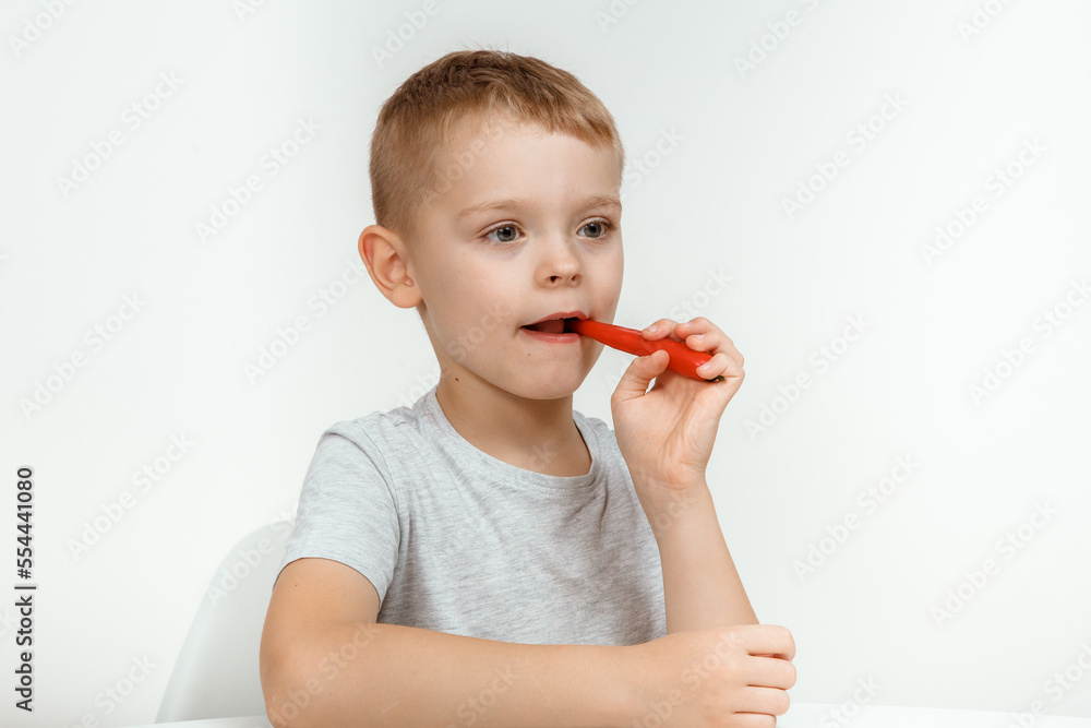 Little boy with chili pepper on white background. Extra hot cayenne ...