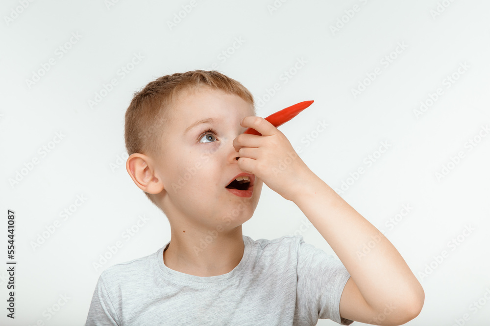 Little boy with chili pepper on white background. Extra hot cayenne ...