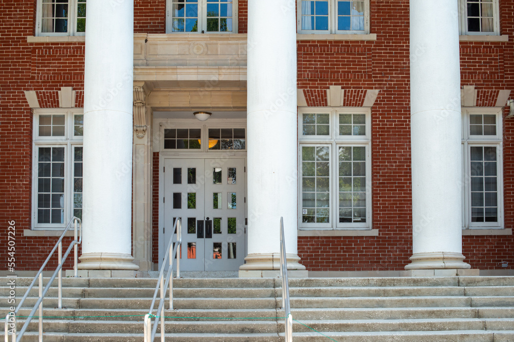 Three large white round columns at the facade entrance to a red vintage ...