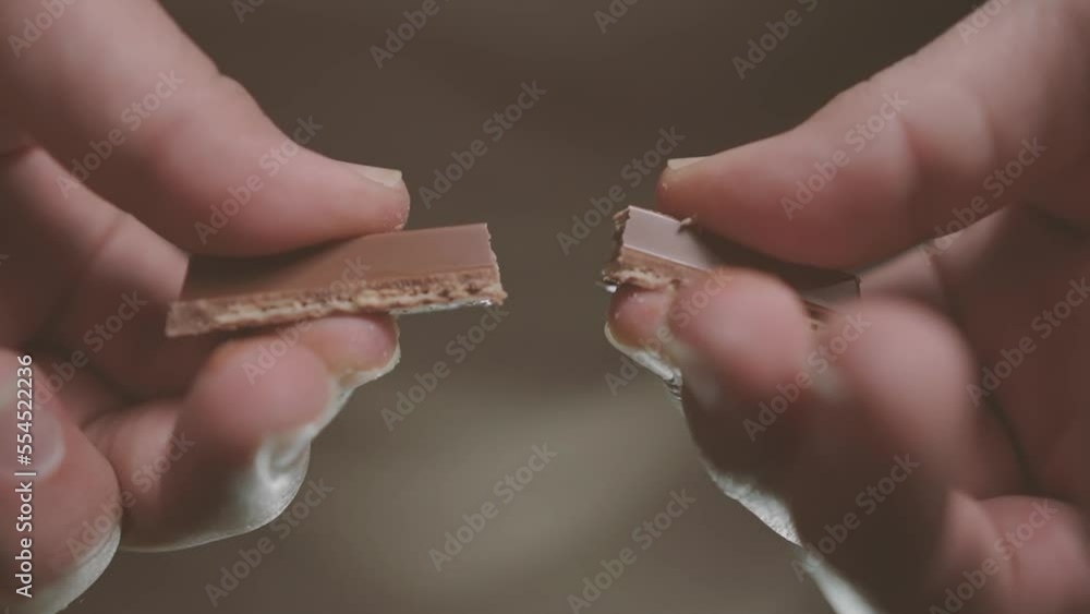 Vidéo Stock Woman breaks chocolate bar. Hands breaking, cracking dark ...