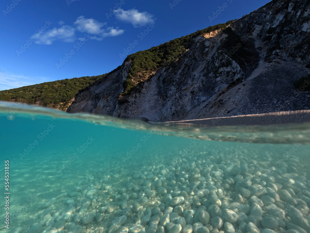 Underwater split sea level photo of famous paradise pebble beach of ...