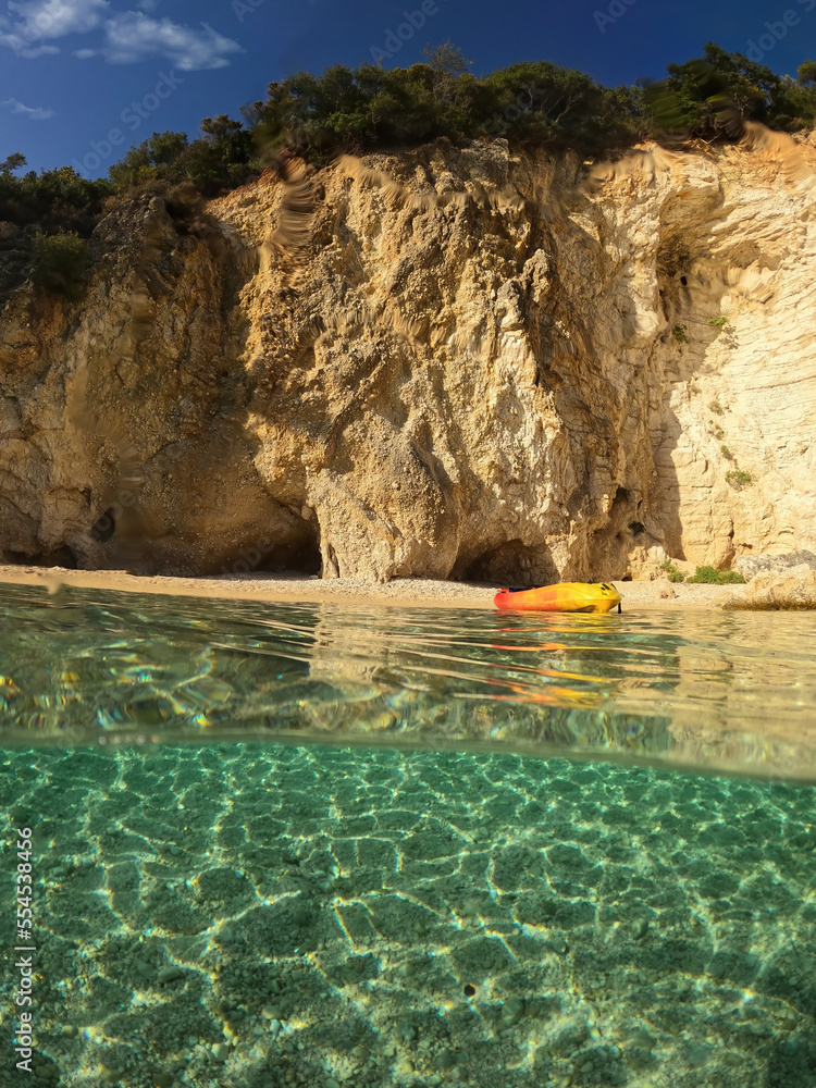 Underwater split photo of sport canoe in crystal clear emerald sea and ...