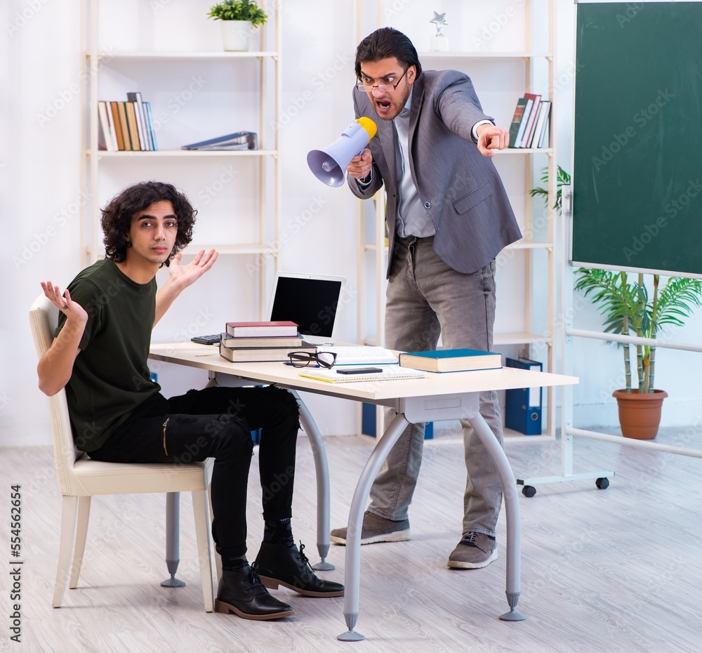 Young teacher and student in the classroom Stock Photo | Adobe Stock