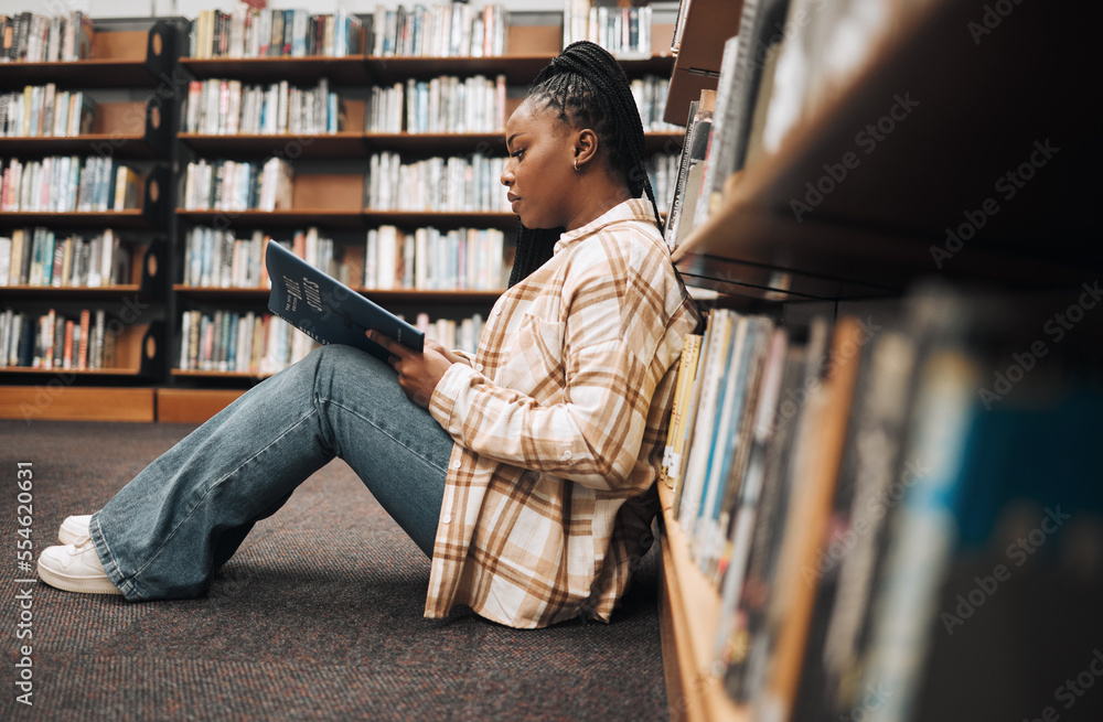 Library, college student and black woman reading books on ground floor ...