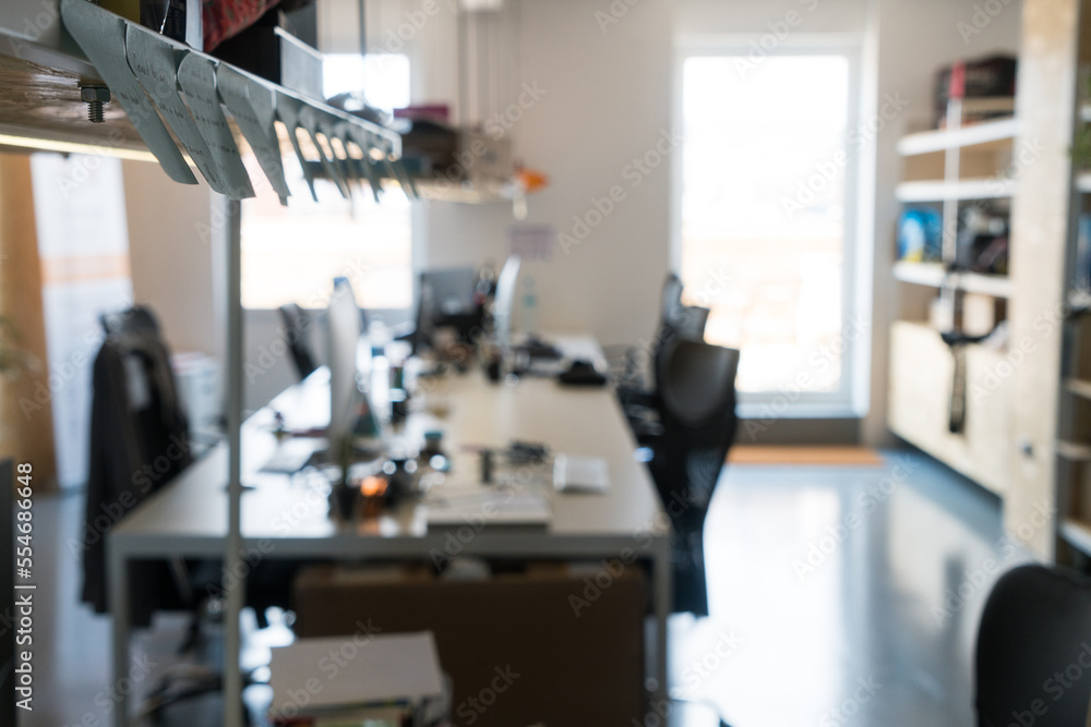 Focus on post its in an empty coworking space with empty seats and desk ...
