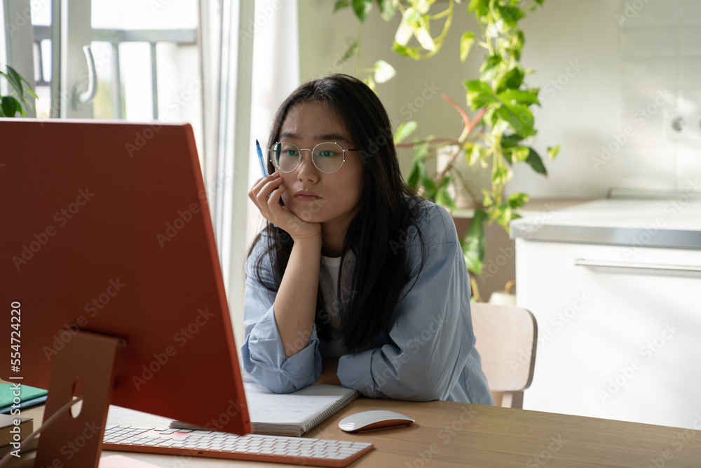 Foto de Young serious Asian girl student watching webinar video course ...