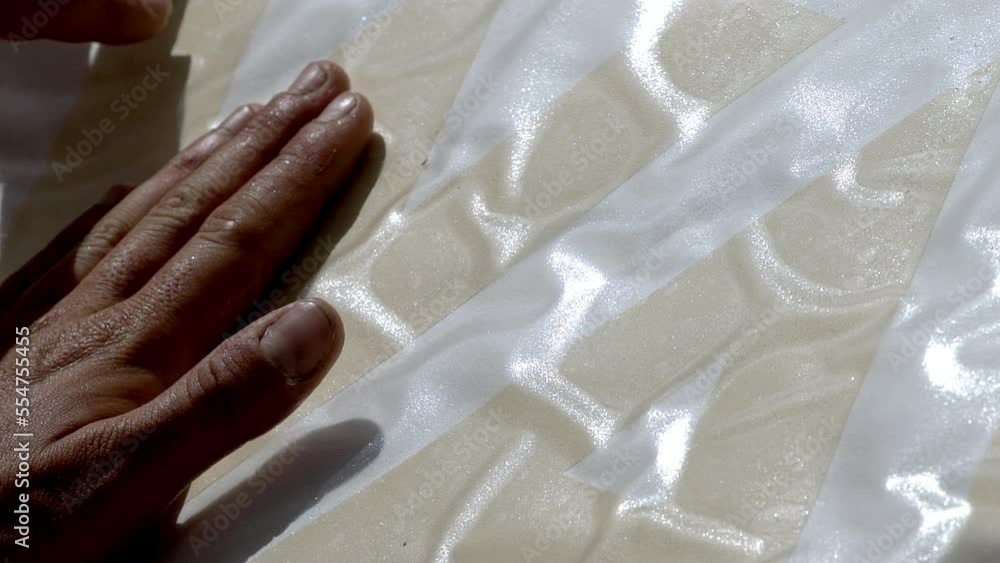 detail of stickers on a skate ramp are glued with both hands in a ...