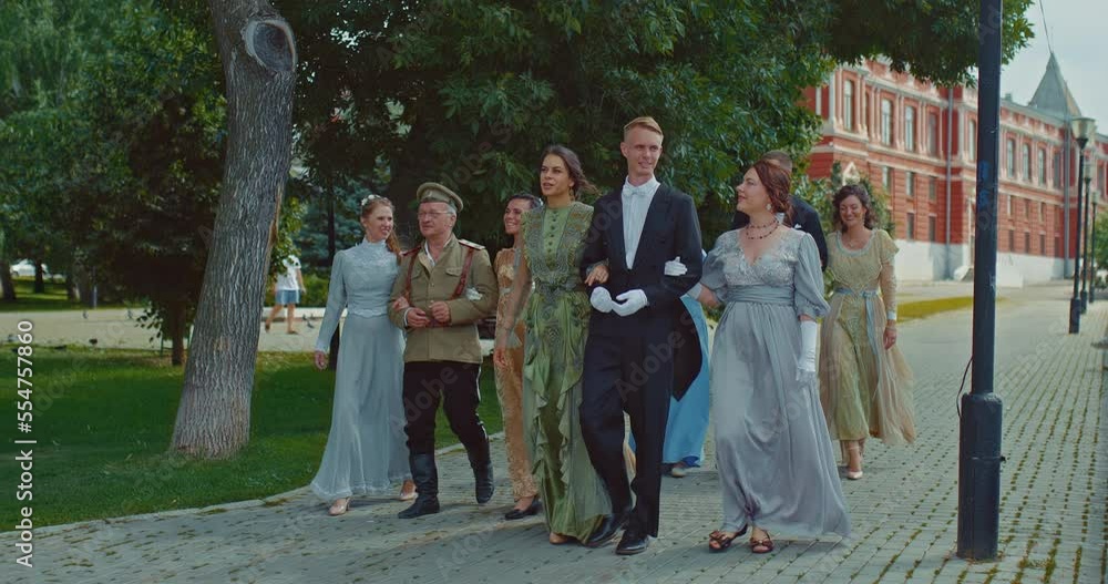 Elegant ladies in historical dresses with lace walk arm in arm with ...