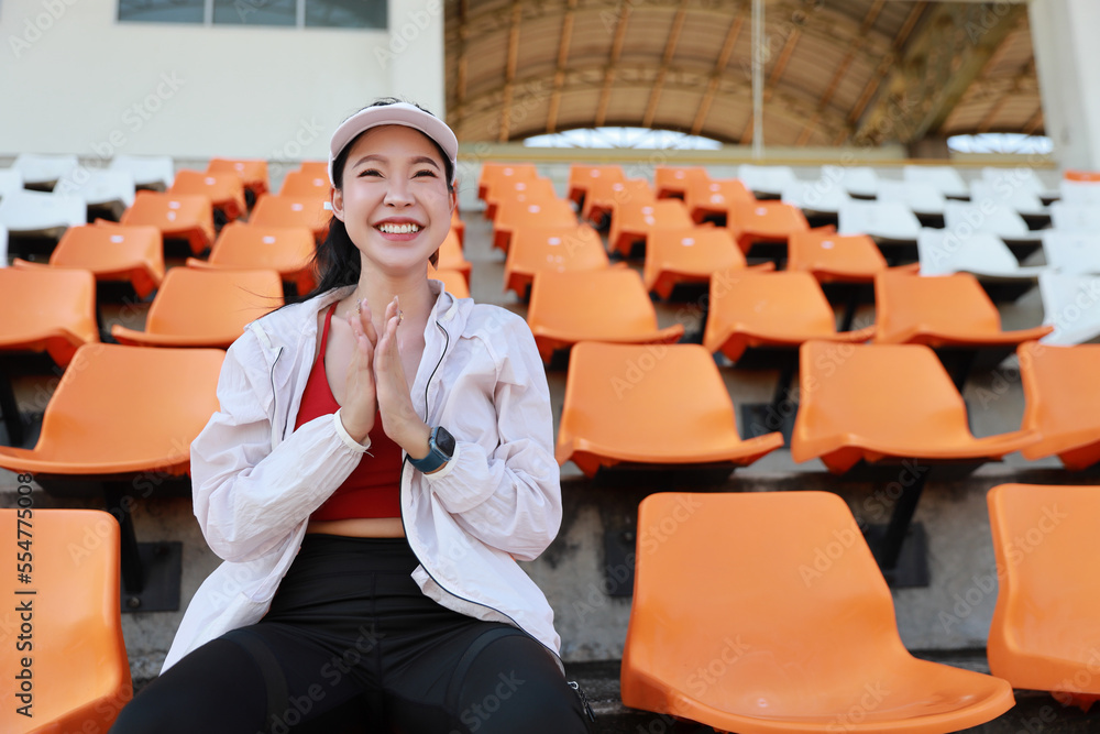 Portrait of happy and excited young female asian sport fan cheering and ...