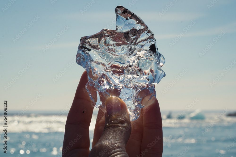 Close up man holding ice on beach concept photo. Northern site. First ...