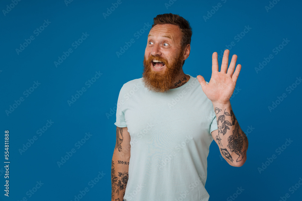Ginger excited man with tattoo smiling and waving hand at camera Stock ...