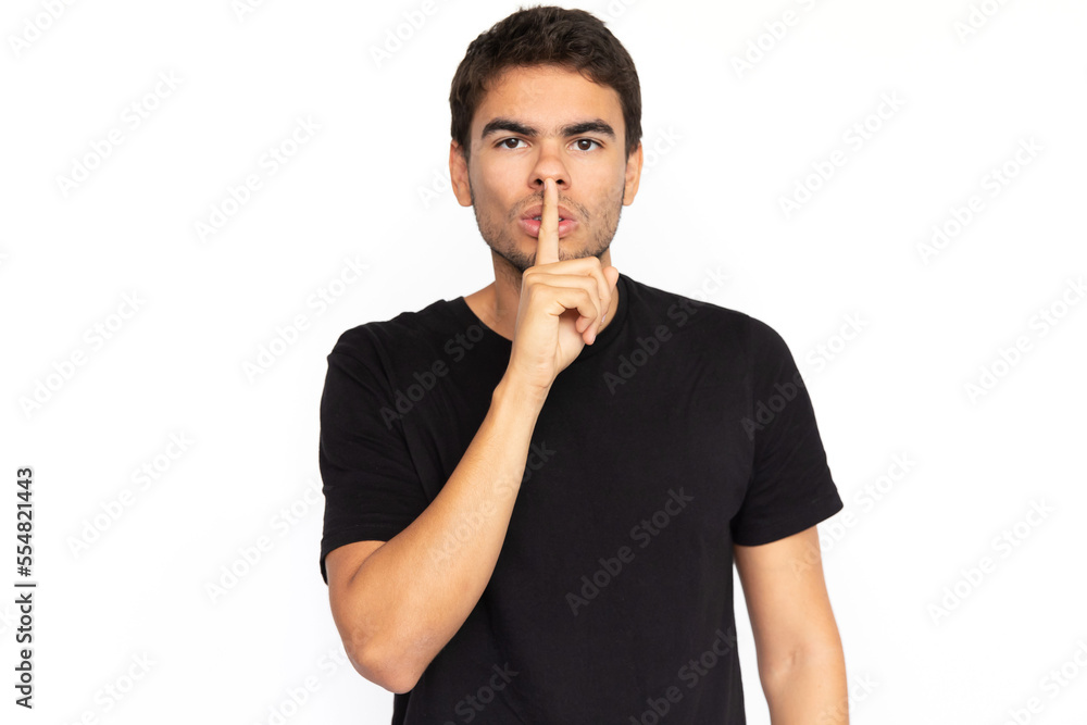 Serious young man shushing. Portrait of strict Caucasian male model ...