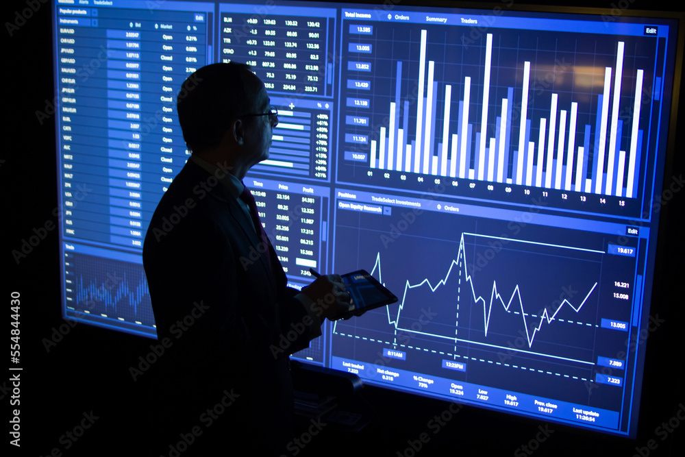 Stock exchange worker analyzing charts. Caucasian man in business suit ...