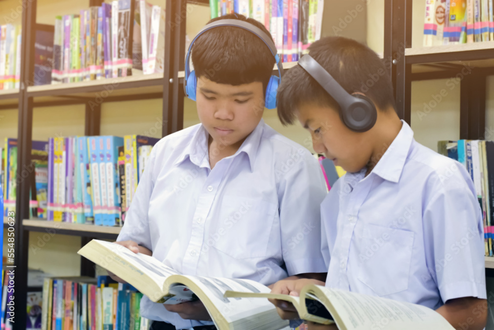 Blurred image of two asian boy students are reading and consulting ...