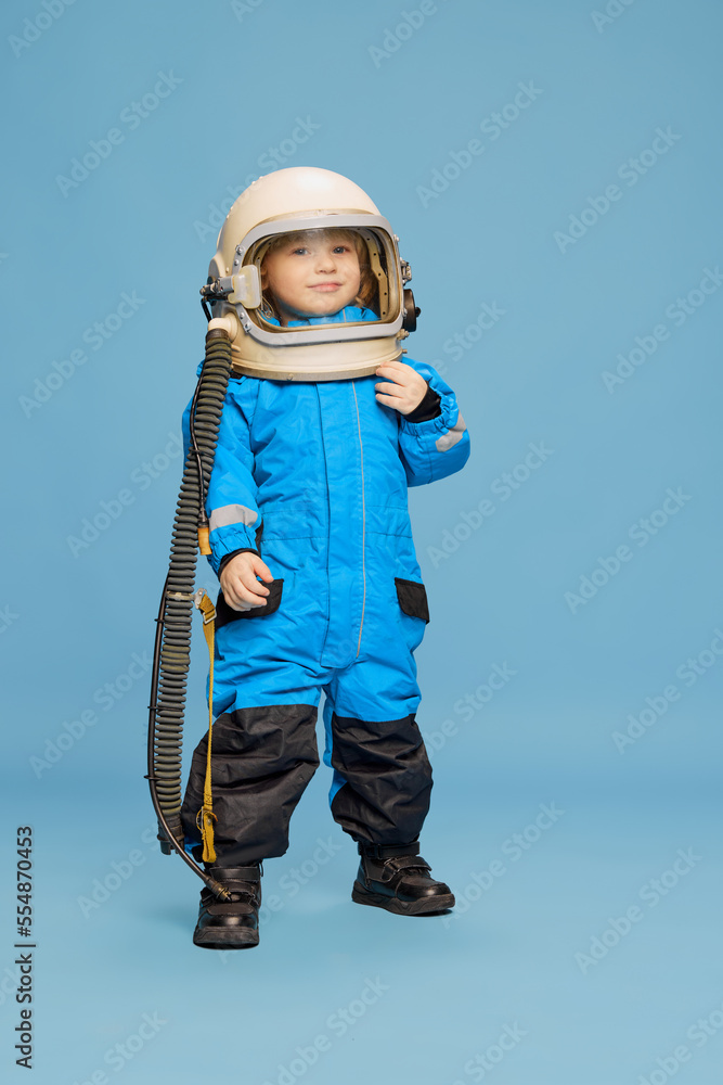 Portrait of little boy, child posing in astronaut costume over blue ...
