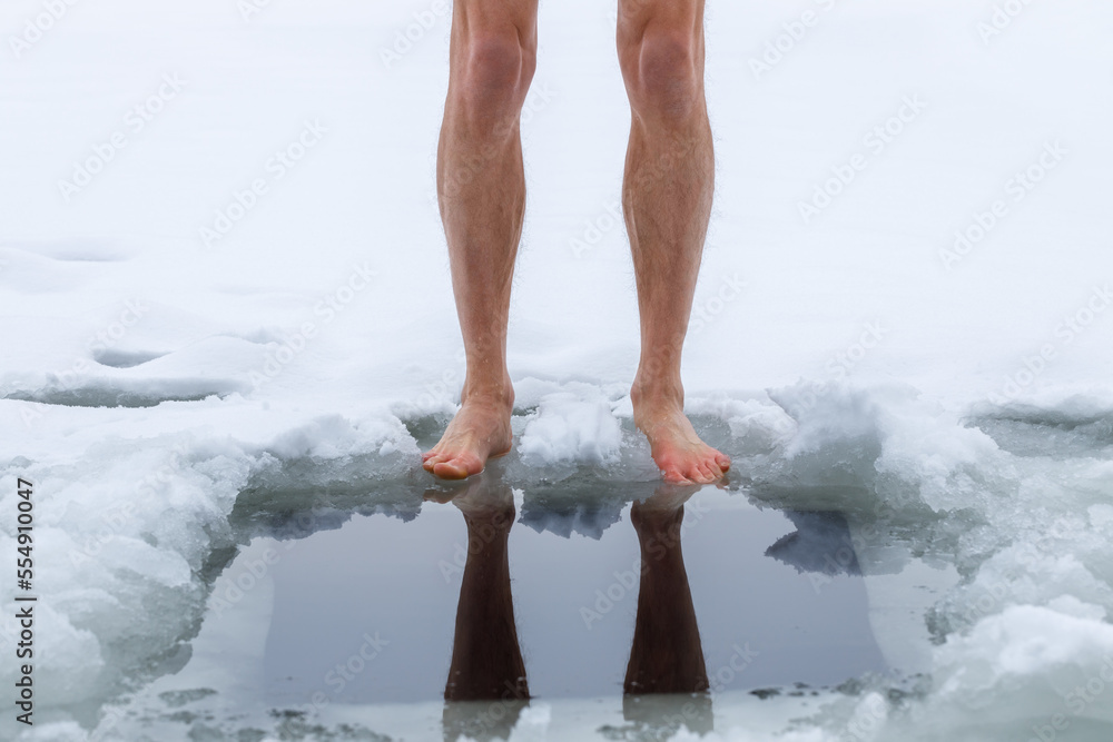 Winter hardening in cold water. Men's legs and a hole close-up. Stock ...