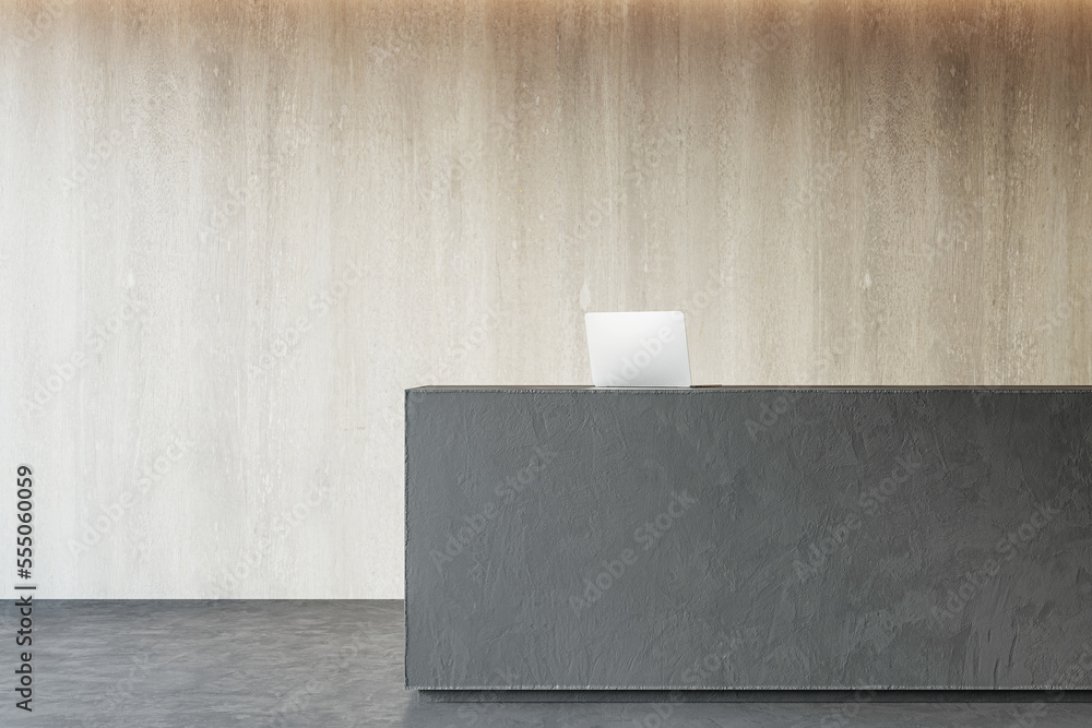 Front view on modern dark concrete reception desk with laptop on light ...