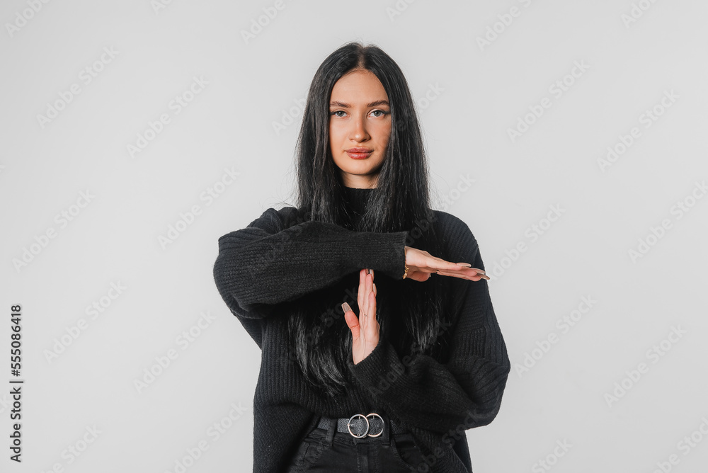 Young woman showing time out hand gesture to stop something, standing ...