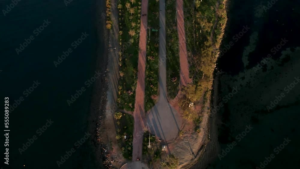 Aerial tilt view of red pedestrian bridge and Inciralti City Forest ...