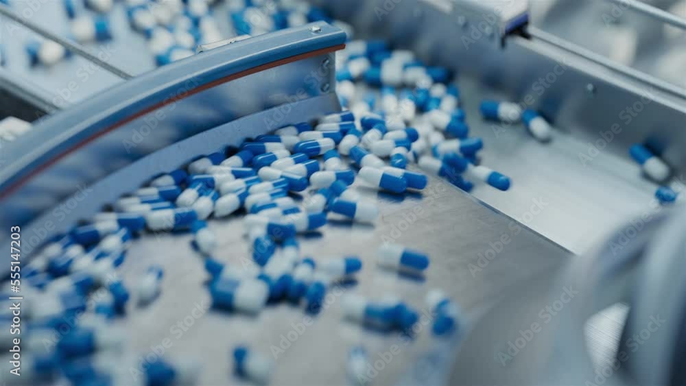 Blue Capsules are Moving on Conveyor at Modern Pharmaceutical Factory ...