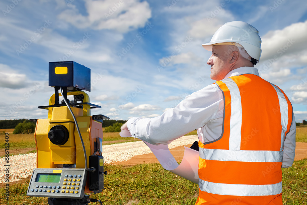 Surveyor in field. Man with geodetic instrument. Road construction ...