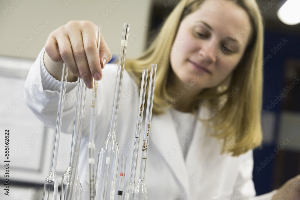 Female scientist removing volumetric pipette from a pipette rack Stock ...