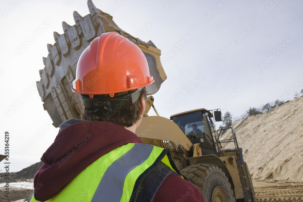 Engineer looking at a front-end loader at a construction site Stock ...