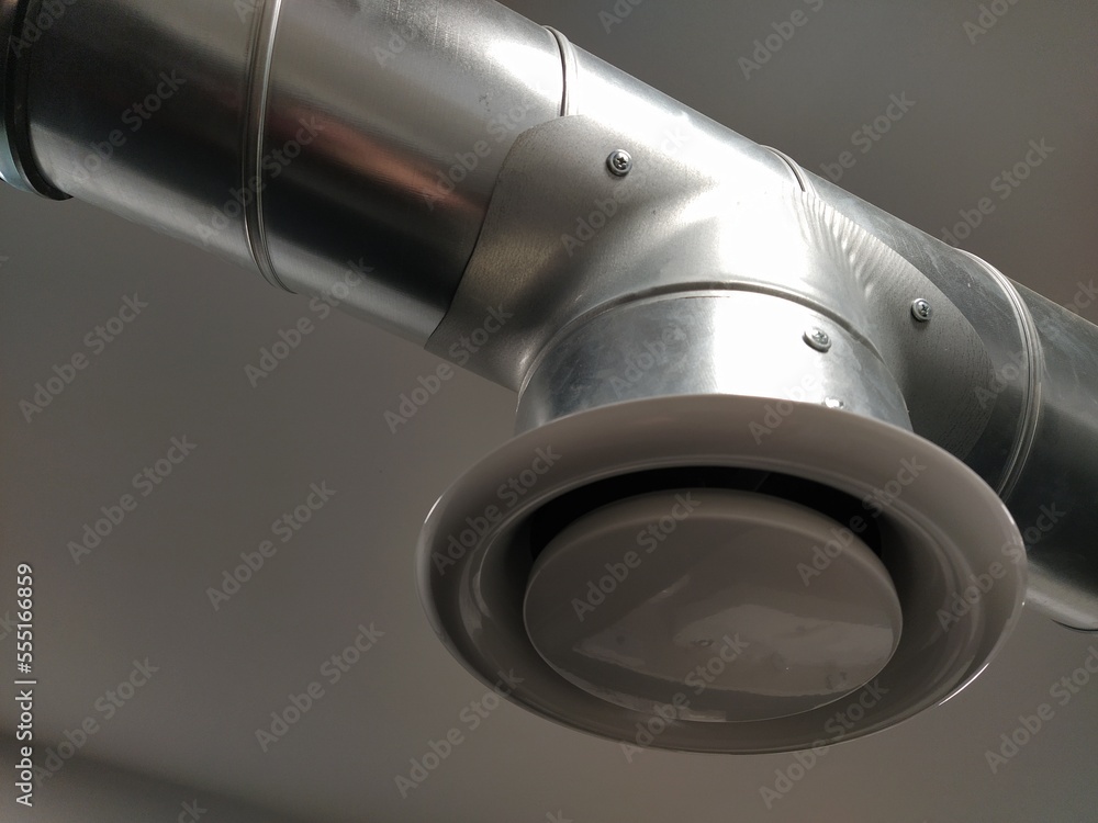 Foto Stock Extractor hood in a public toilet. Round metal pipe with ...