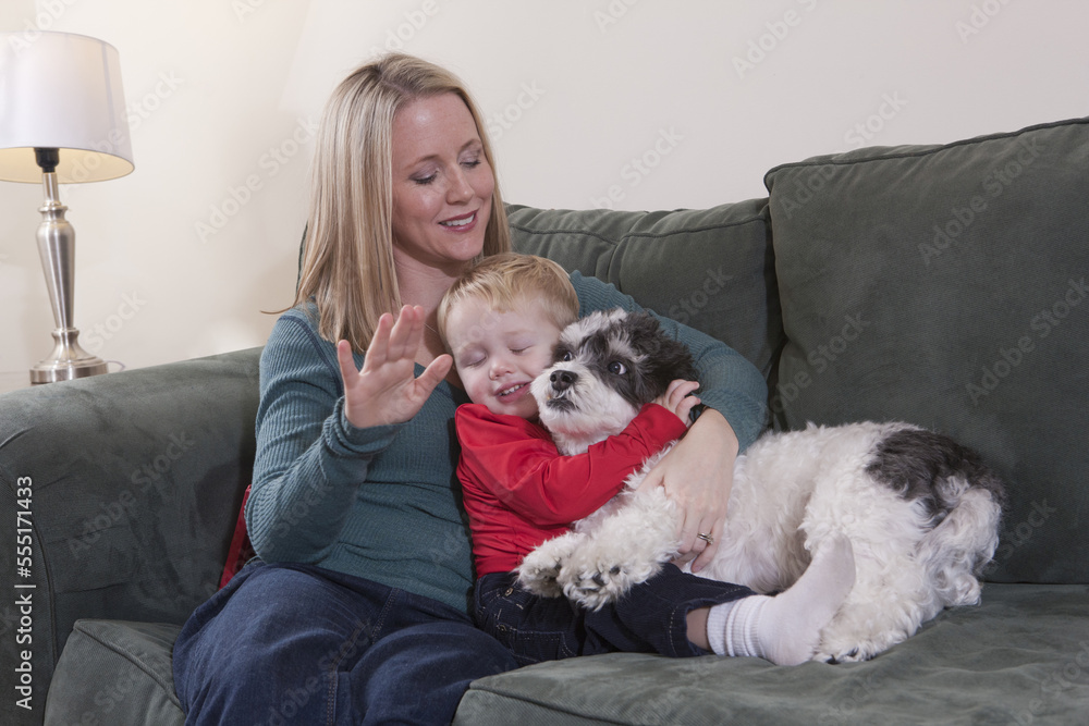 Woman signing the word 'Puppy' in American Sign Language while her son ...