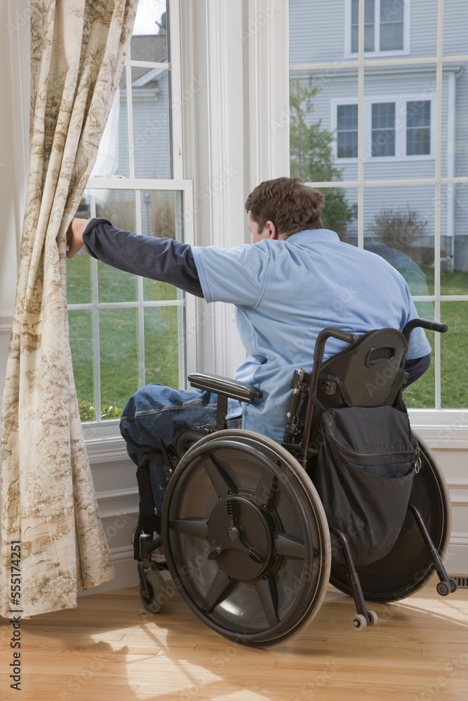 Foto de Man with spinal cord injury in a wheelchair looking out the ...