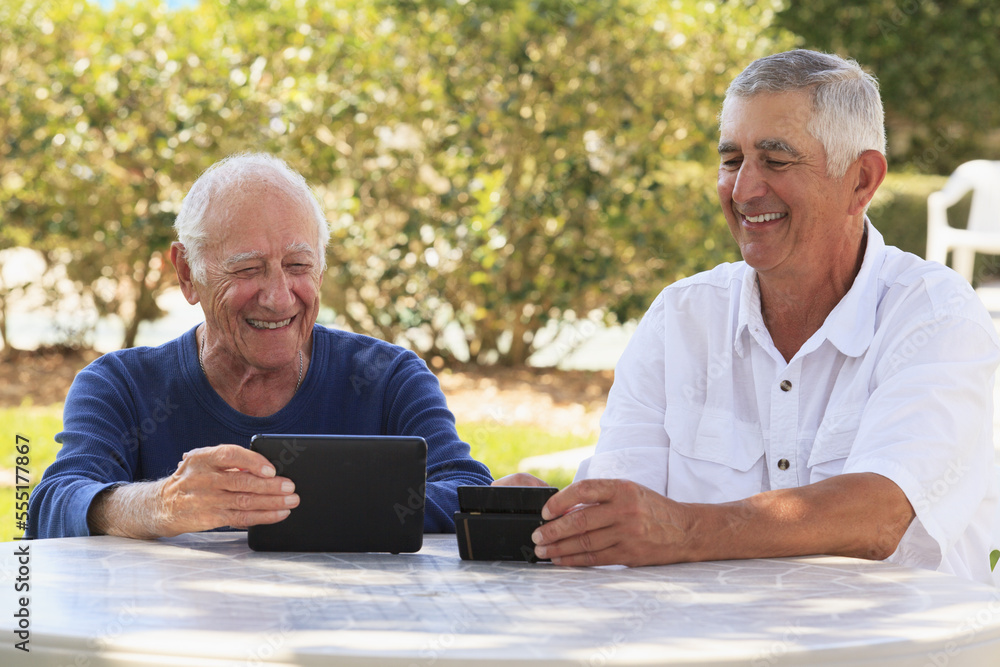 Elderly father, who is visually impaired, and senior son using ...