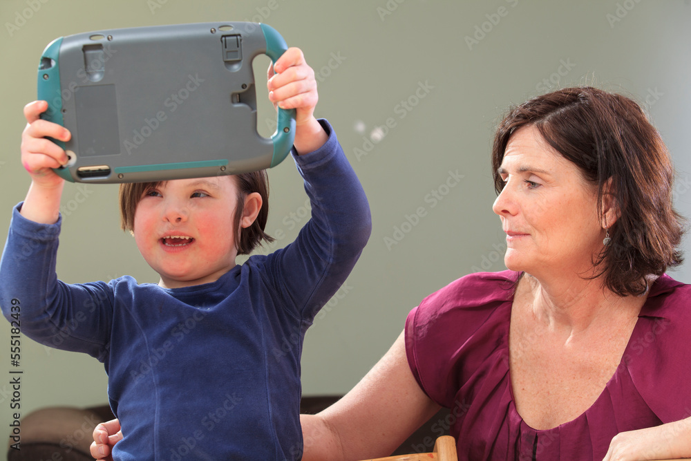 Little girl with Down Syndrome playing an electronic learning game with ...