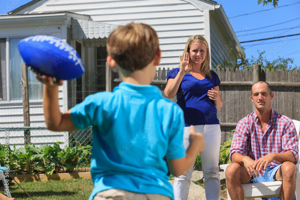 Family with hearing impairments playing football and signing in ...