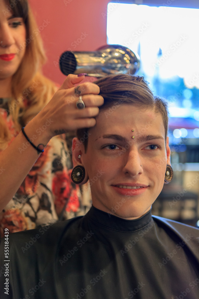 Trendy man with a spinal cord injury at a hair salon getting a hair cut ...
