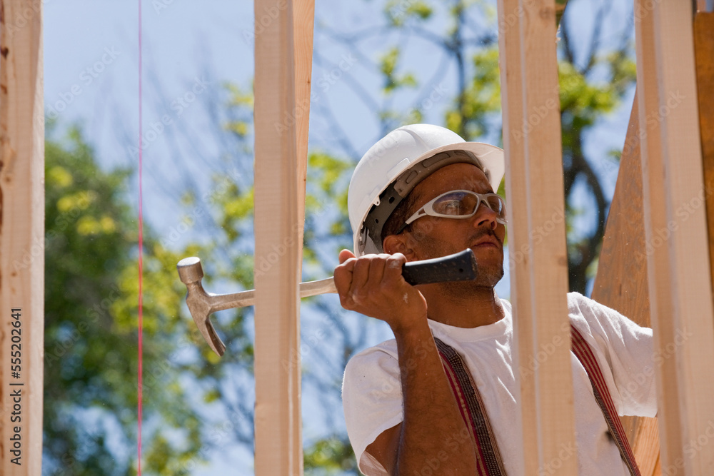 Carpenter using framing hammer on a house frame Stock Photo | Adobe Stock